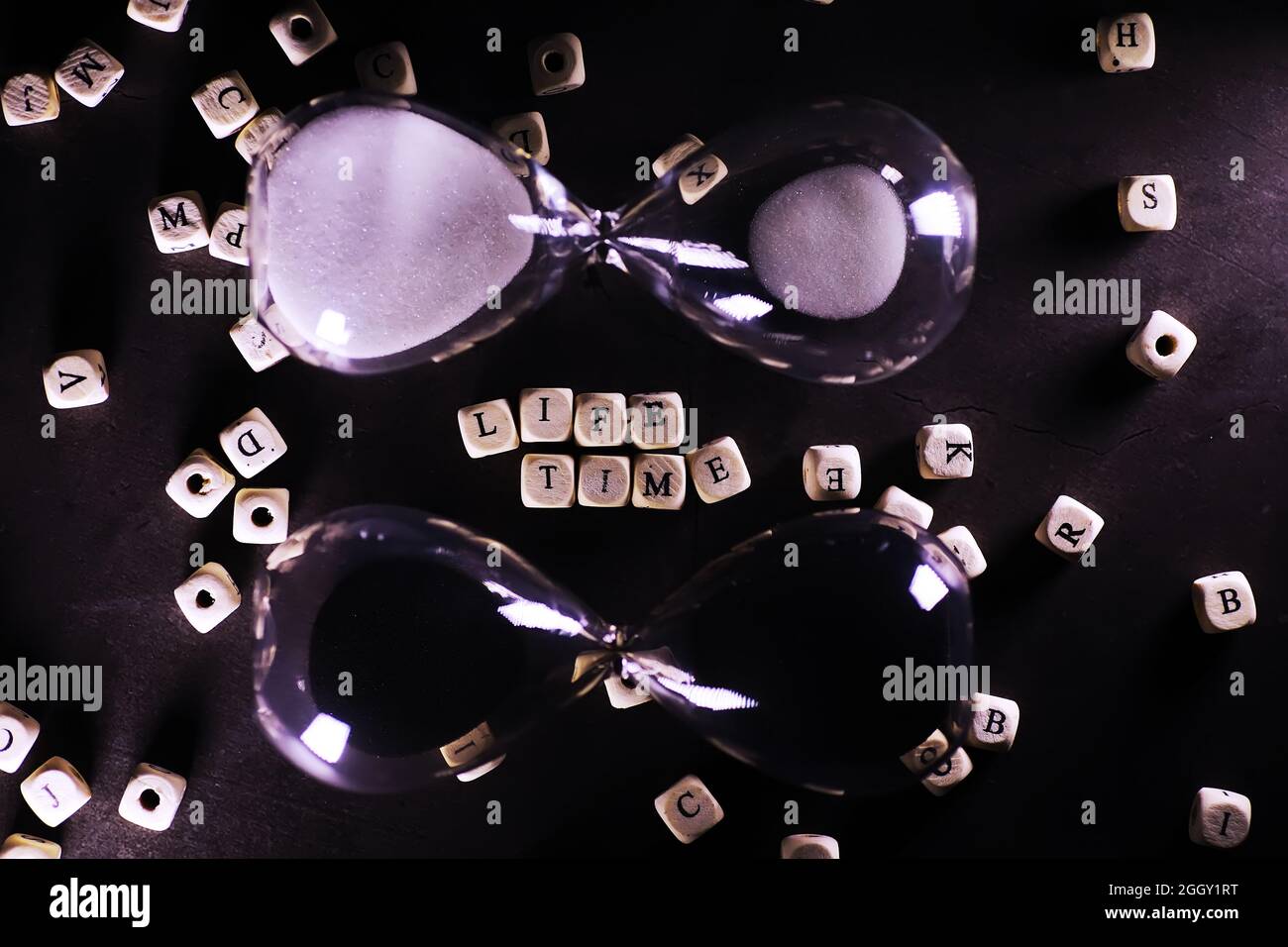 Sand running through the bulbs of an hourglass measuring the passing ...