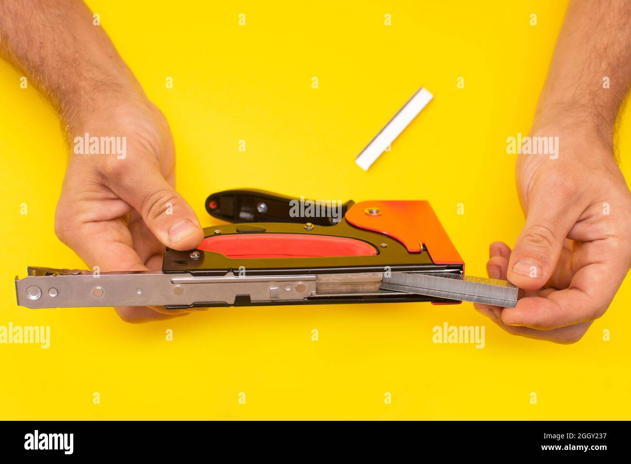 male hands fill the stapler gun with staples Stock Photo - Alamy