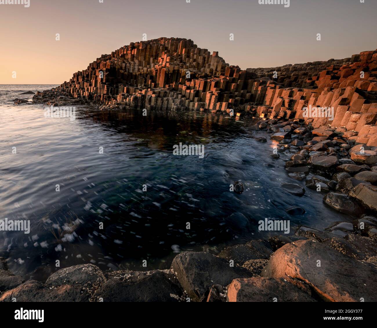 Sunset over the basalt columns of the Giant's Causeway in County Antrim ...