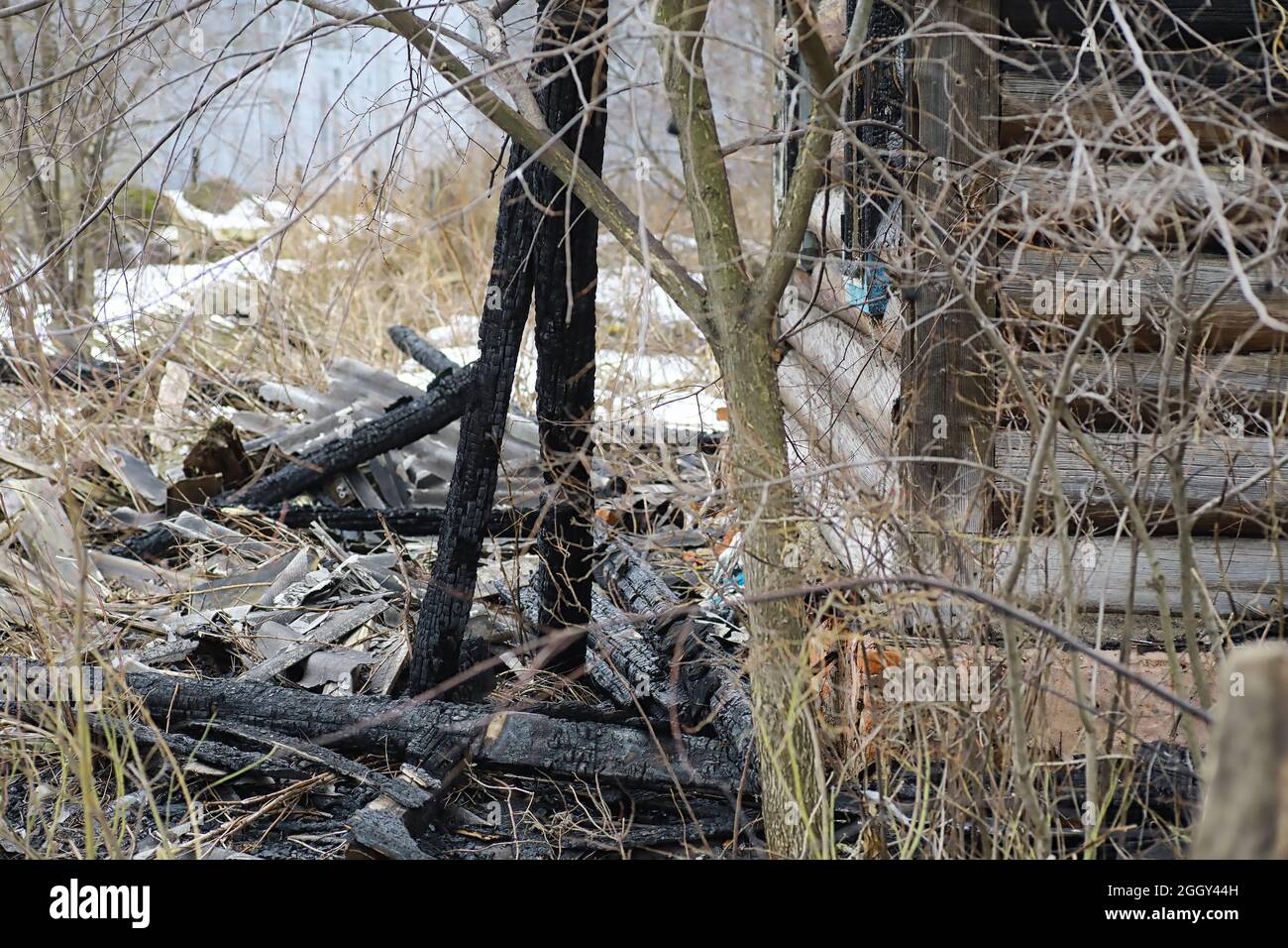Wooden house after the fire. Coals on the logs. The ashes of the house ...