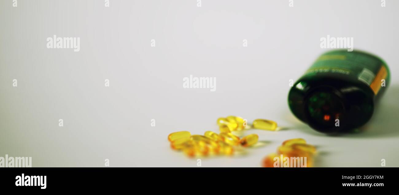 Medical medicines and supplements transparent capsules of yellow color ...