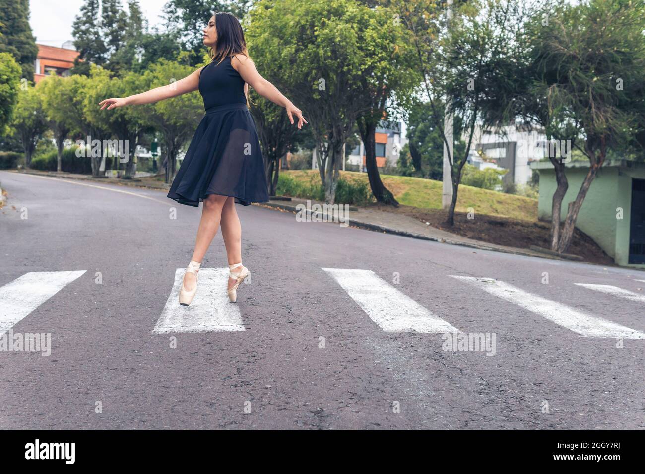 Latin teenage dancer girl with black dress walking elegantly with ...