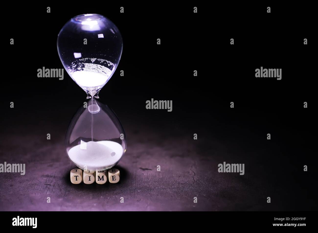Sand running through the bulbs of an hourglass measuring the passing ...