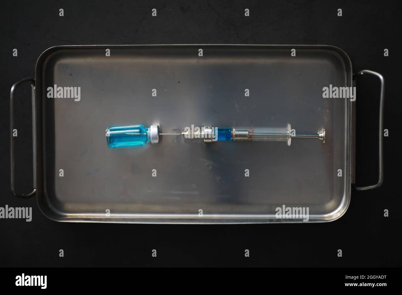 small jars with injection and syringe for injection on blue background ...