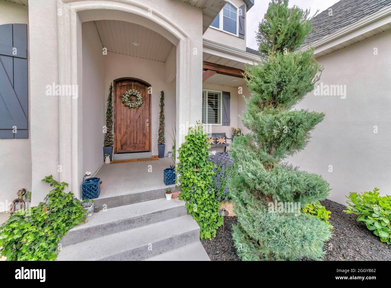 Inviting entrance path of a house with decorated wooden front door ...