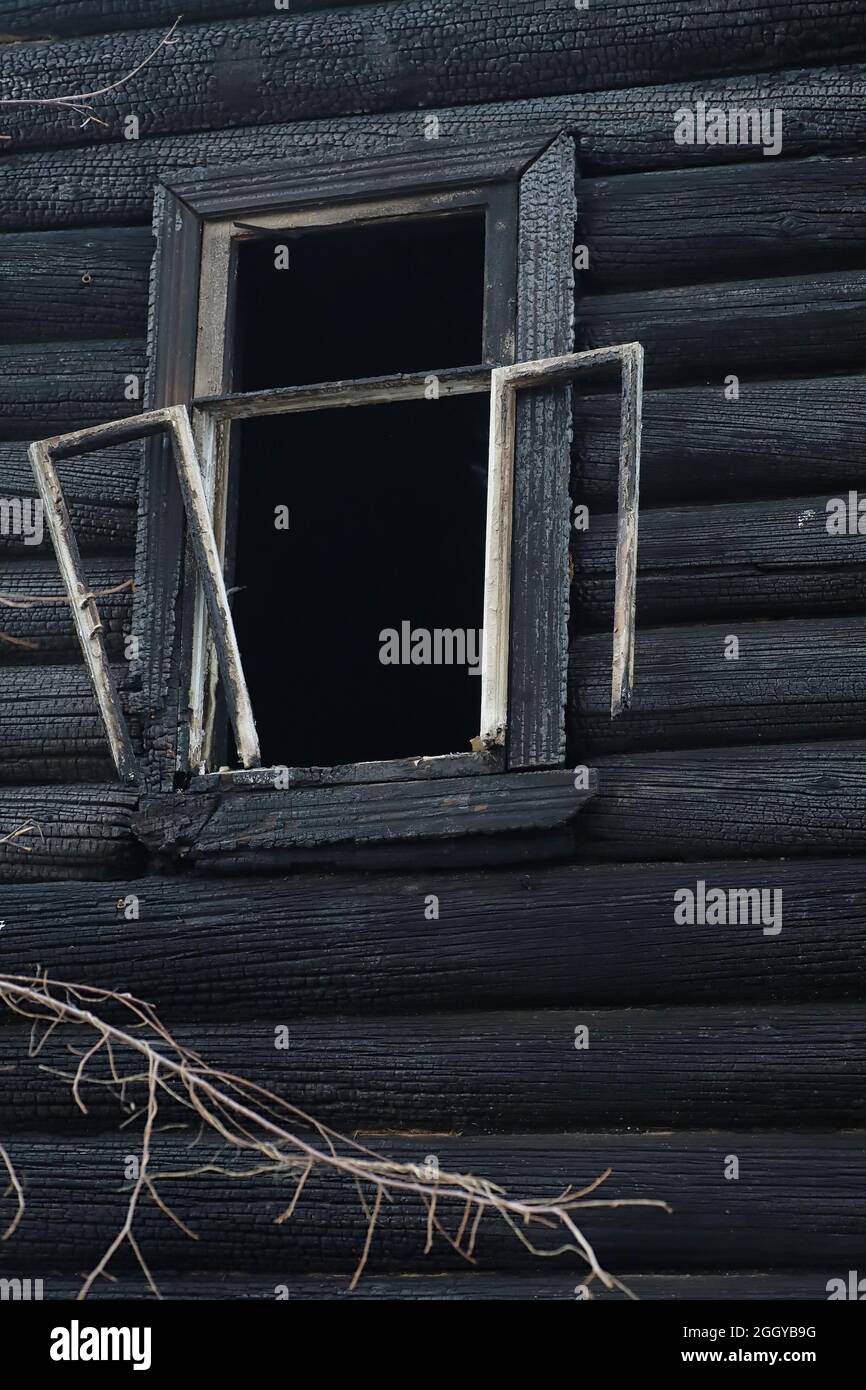 Wooden house after the fire. Coals on the logs. The ashes of the house ...