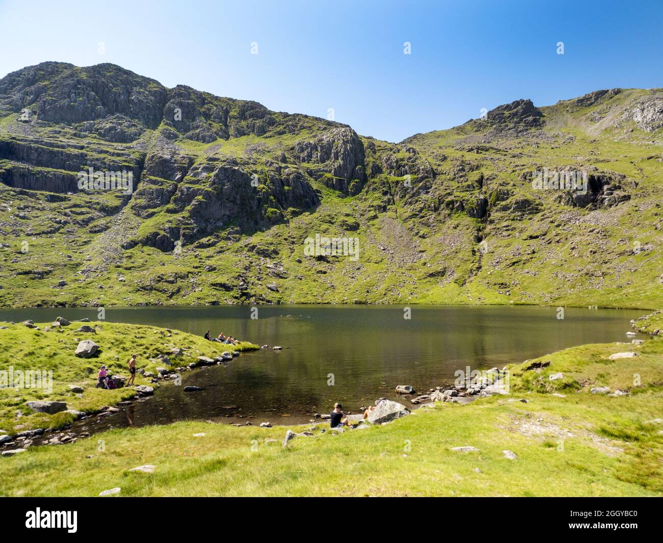 Angle Tarn below Bow Fell with wild swimmers, Lake District, UK Stock ...