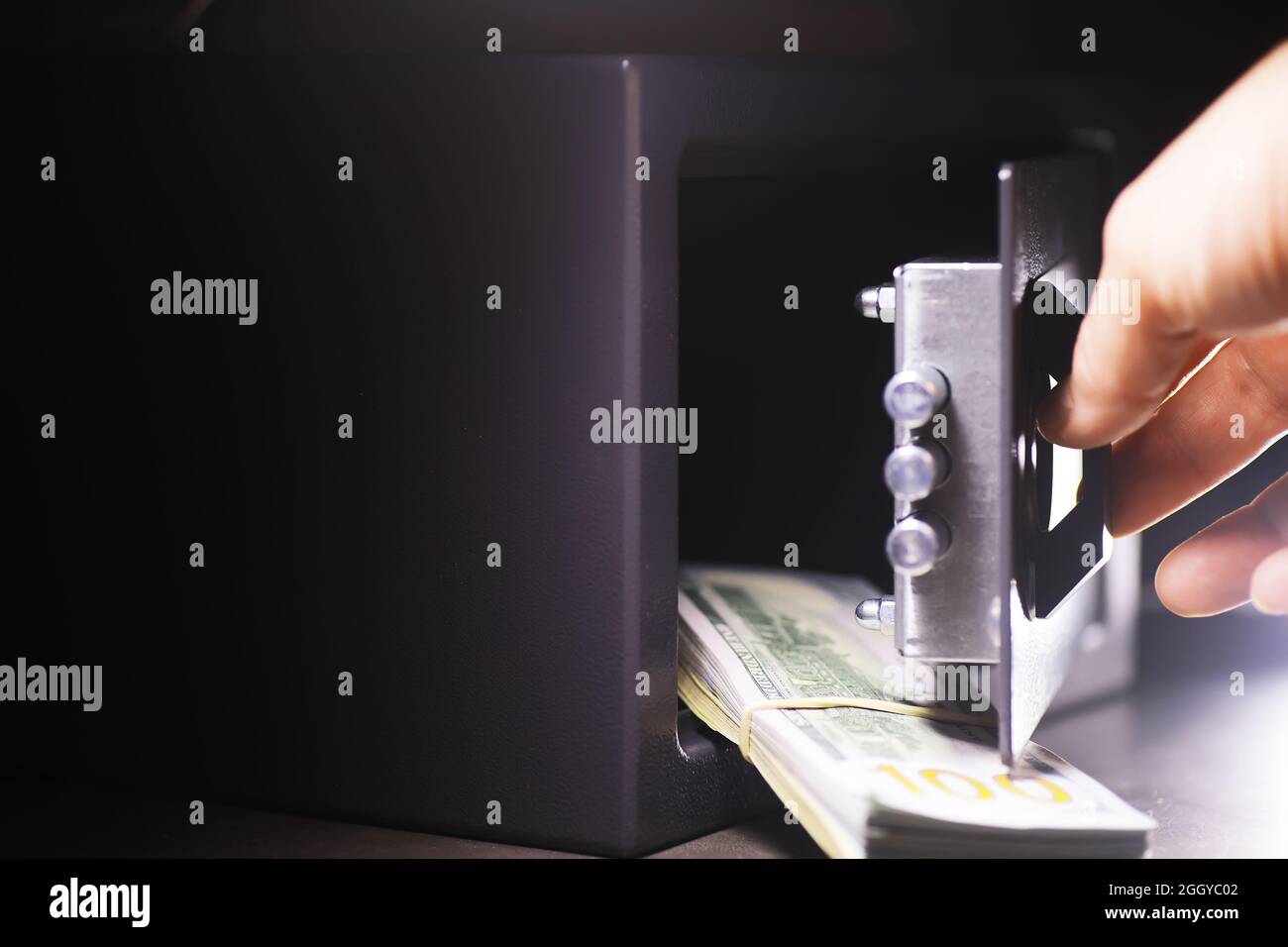 Steel safe with money. Hand putting password in the safety money box in ...