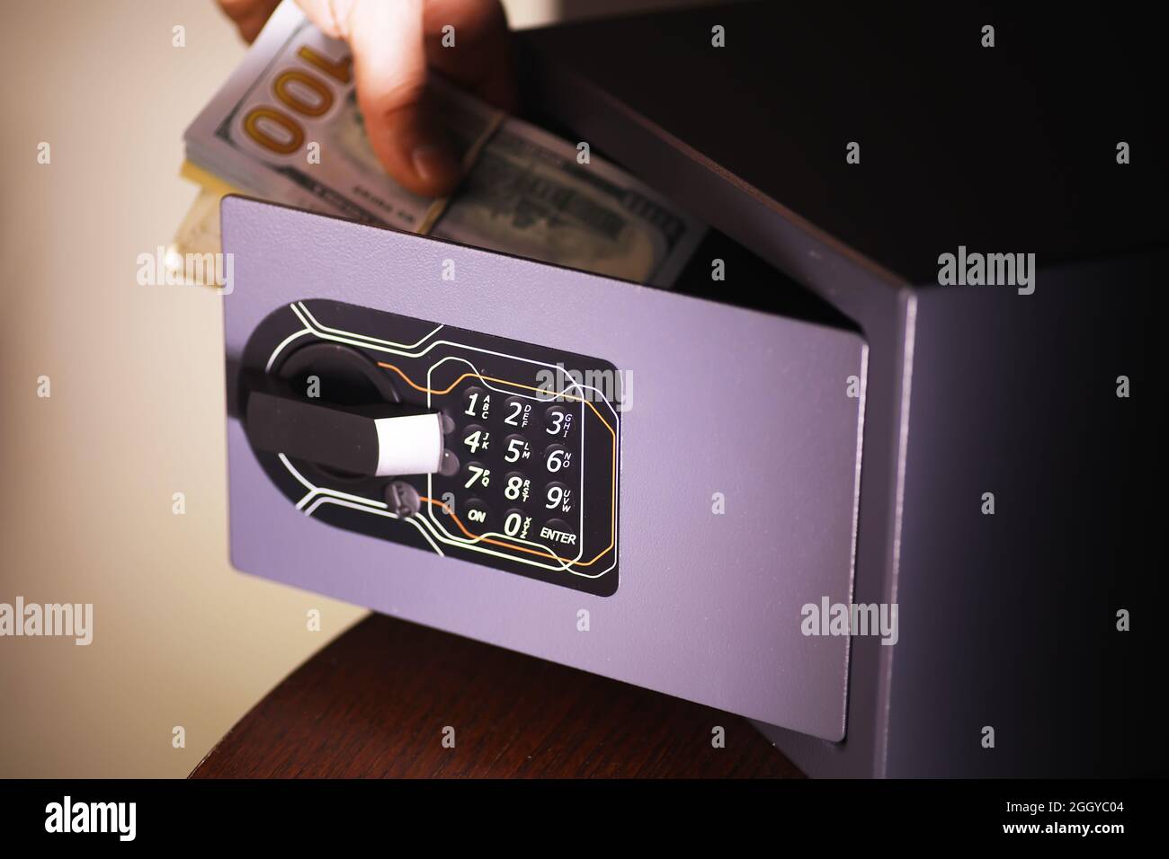Steel safe with money. Hand putting password in the safety money box in ...