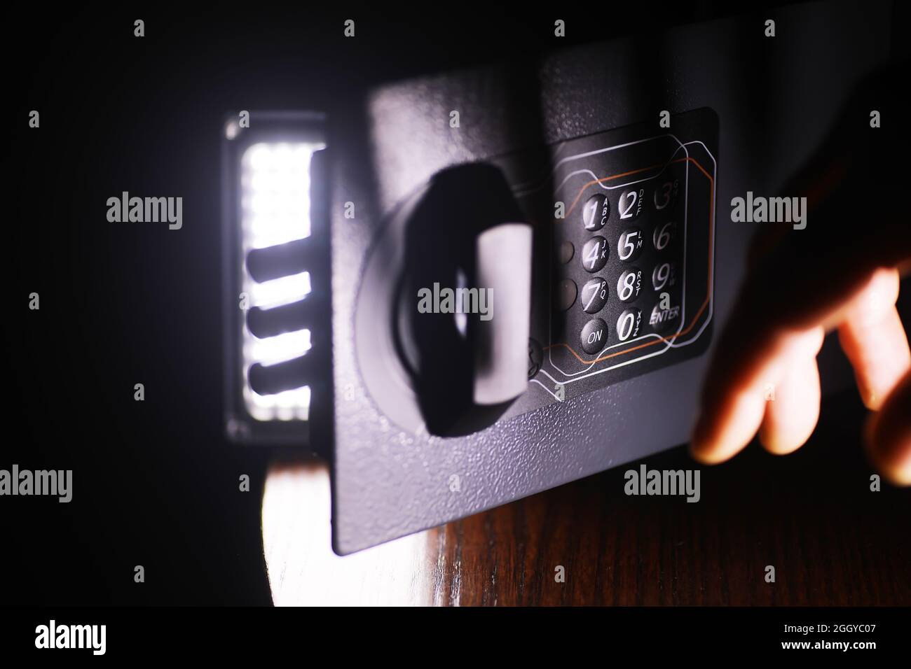 Steel safe with money. Hand putting password in the safety money box in ...