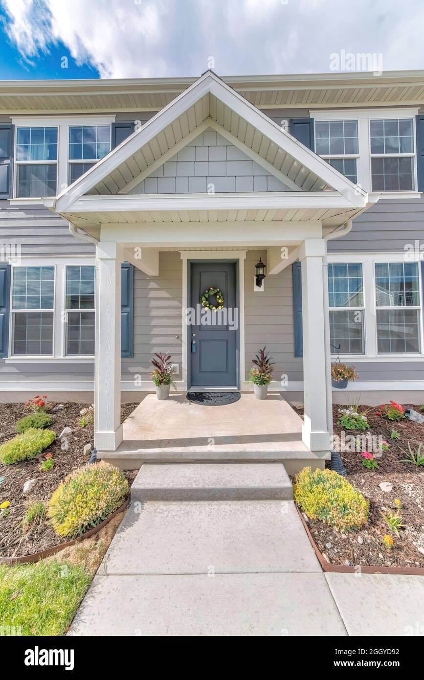 Symmetrical house facade with vinyl wood siding and gray front door ...