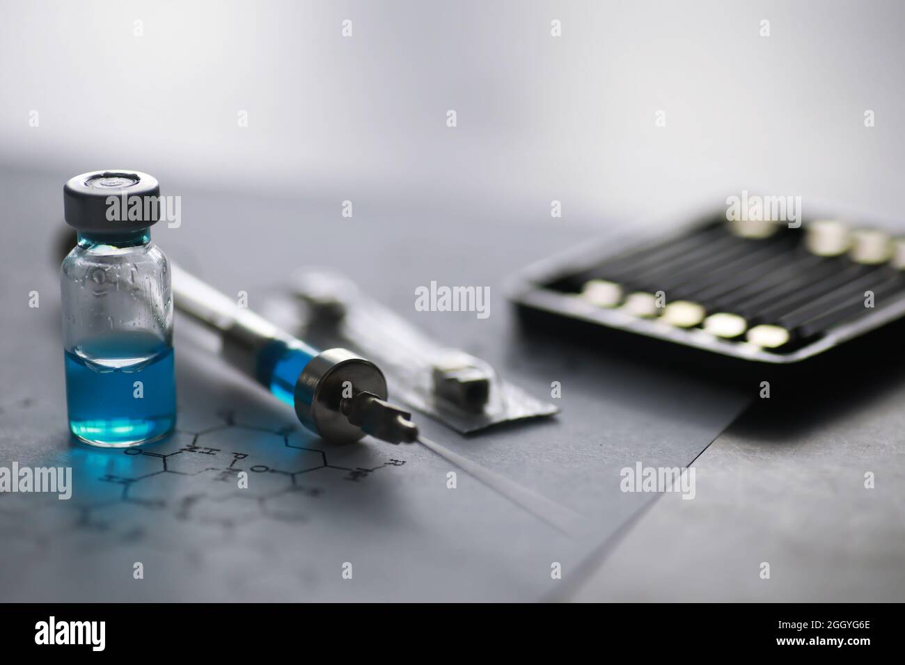small jars with injection and syringe for injection on blue background ...