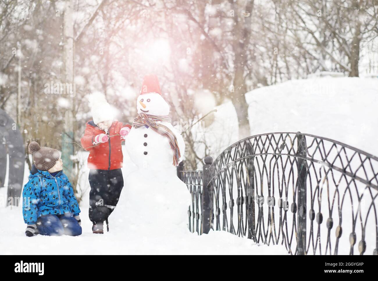 Children in the park in winter. Kids play with snow on the playground ...
