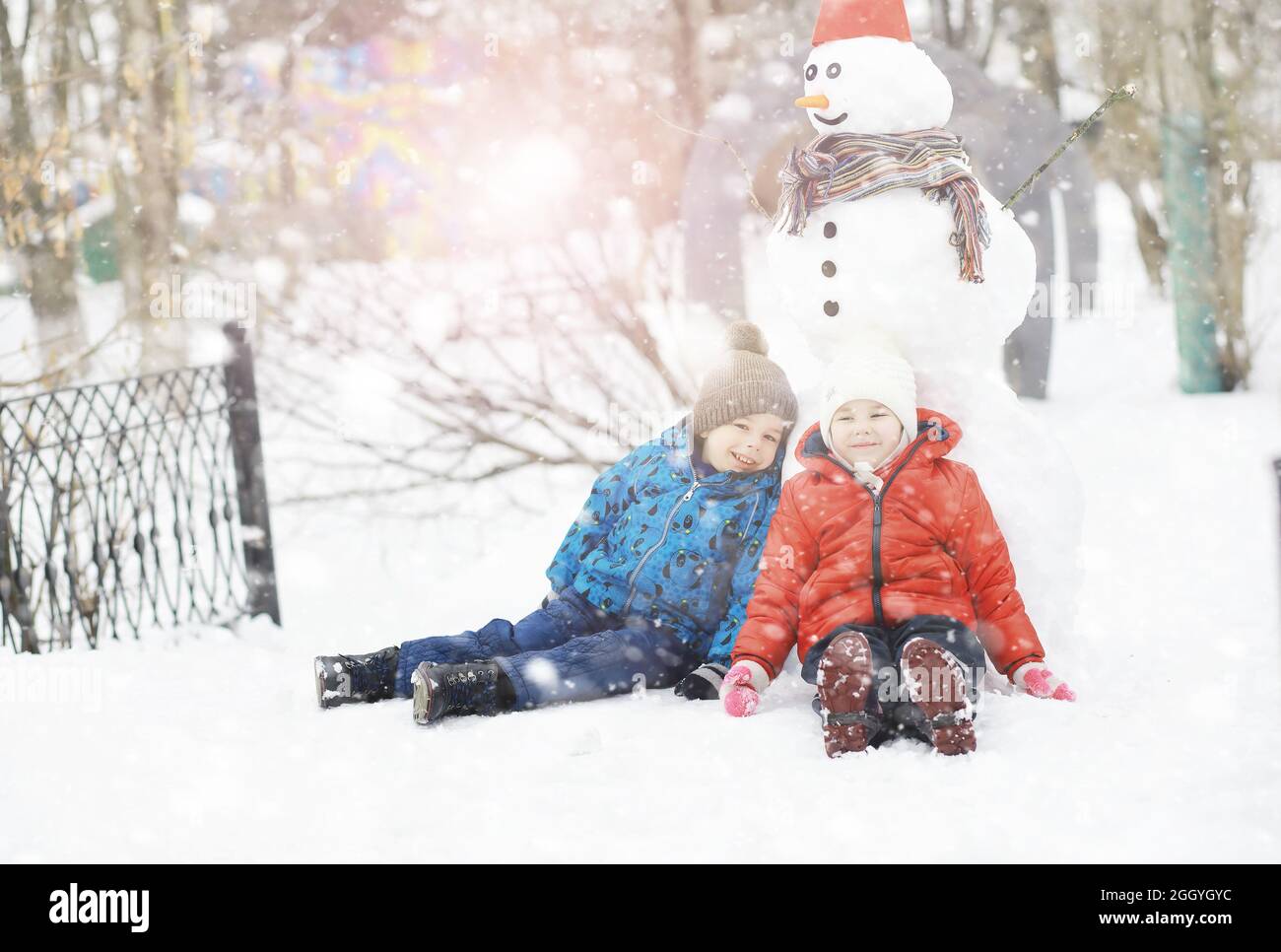 Children in the park in winter. Kids play with snow on the playground ...