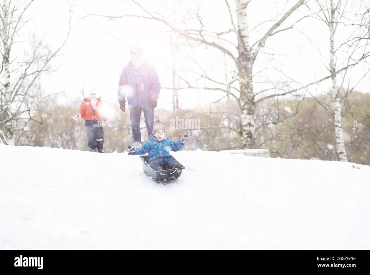 Children in the park in winter. Kids play with snow on the playground ...