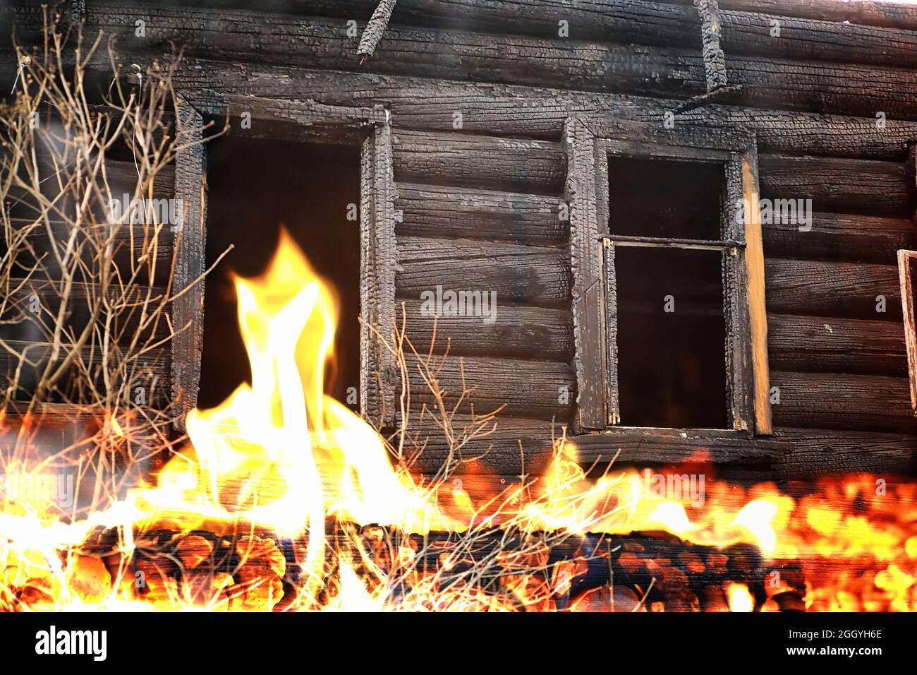 Wooden house after the fire. Coals on the logs. The ashes of the house ...