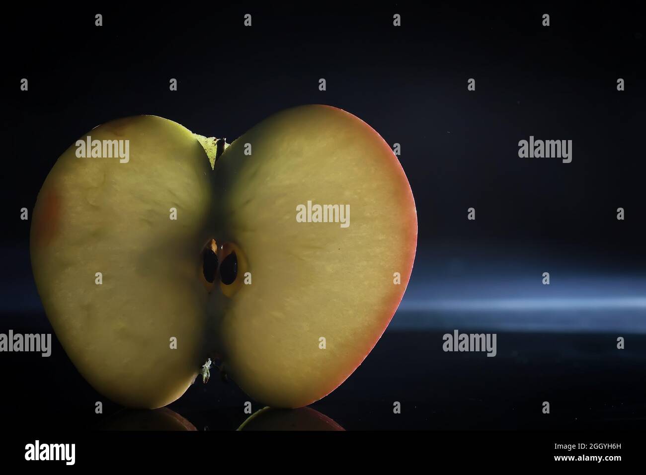 Composition with apple slices on a black background. A slice of apple ...