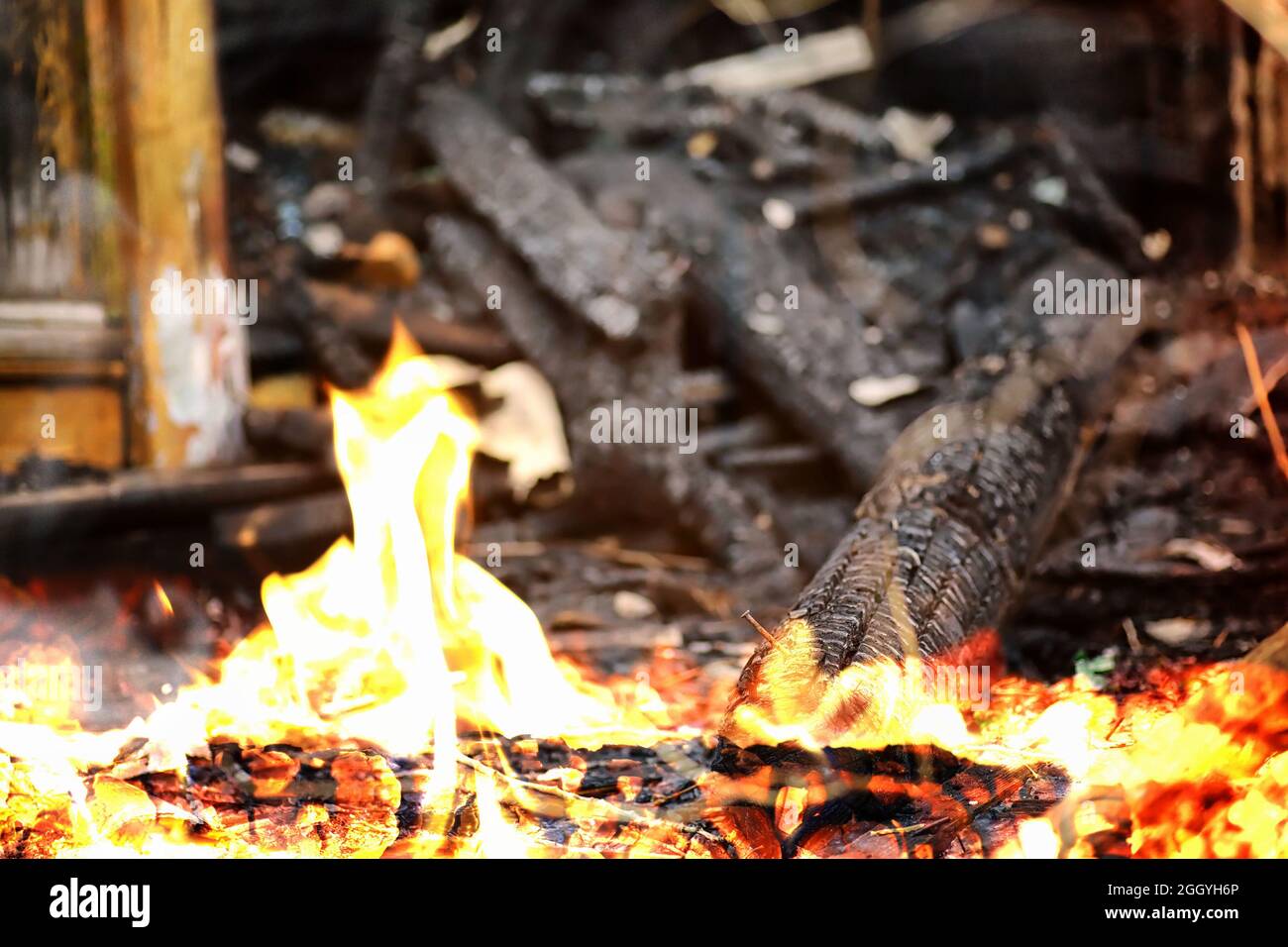 Wooden house after the fire. Coals on the logs. The ashes of the house ...