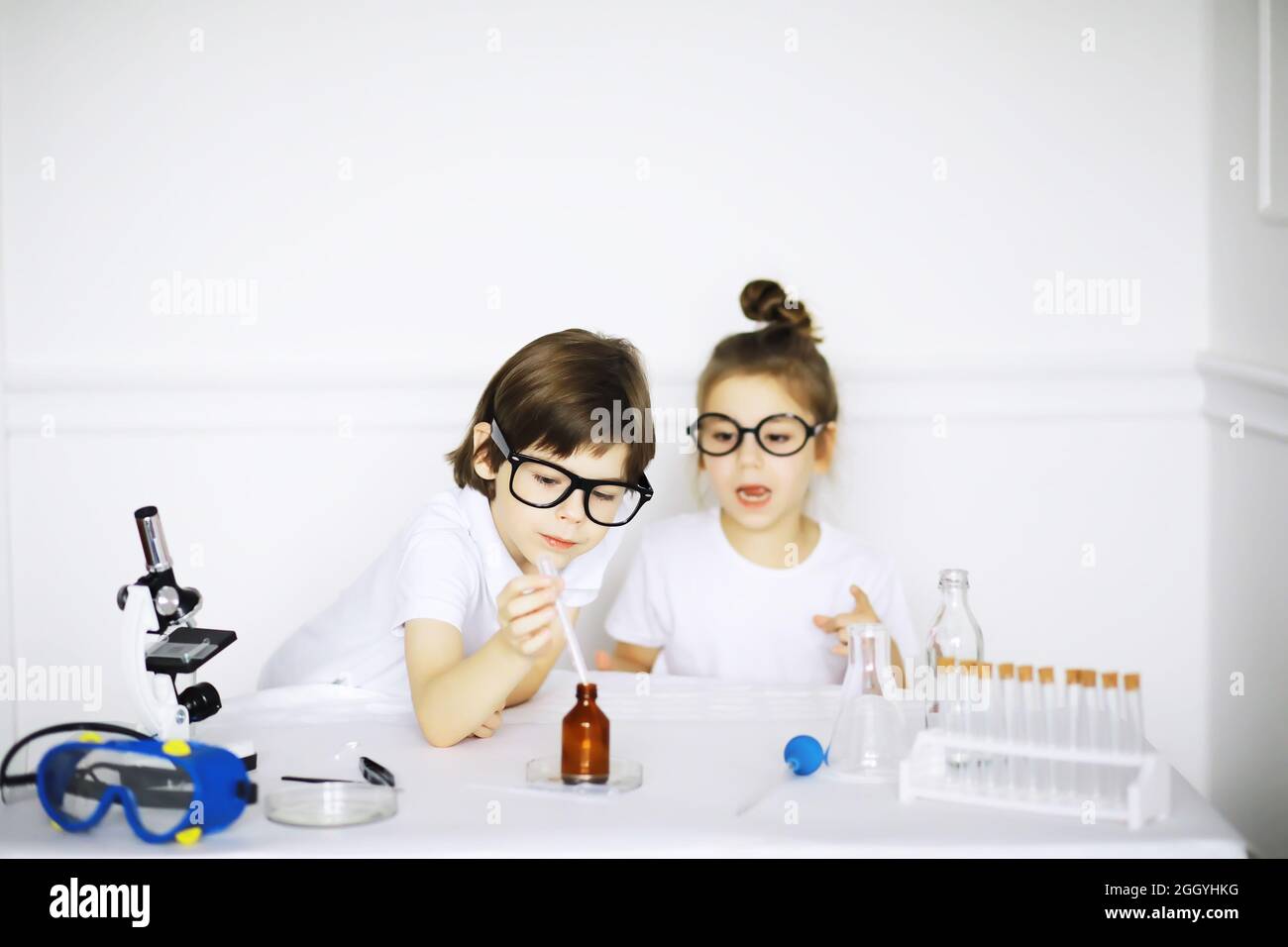 Two cute children at chemistry lesson making experiments isolated on ...