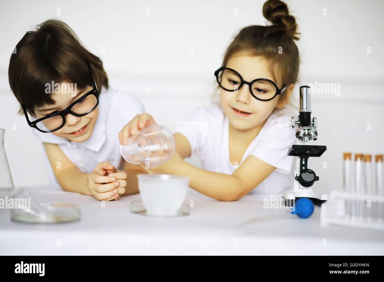 Two cute children at chemistry lesson making experiments isolated on ...