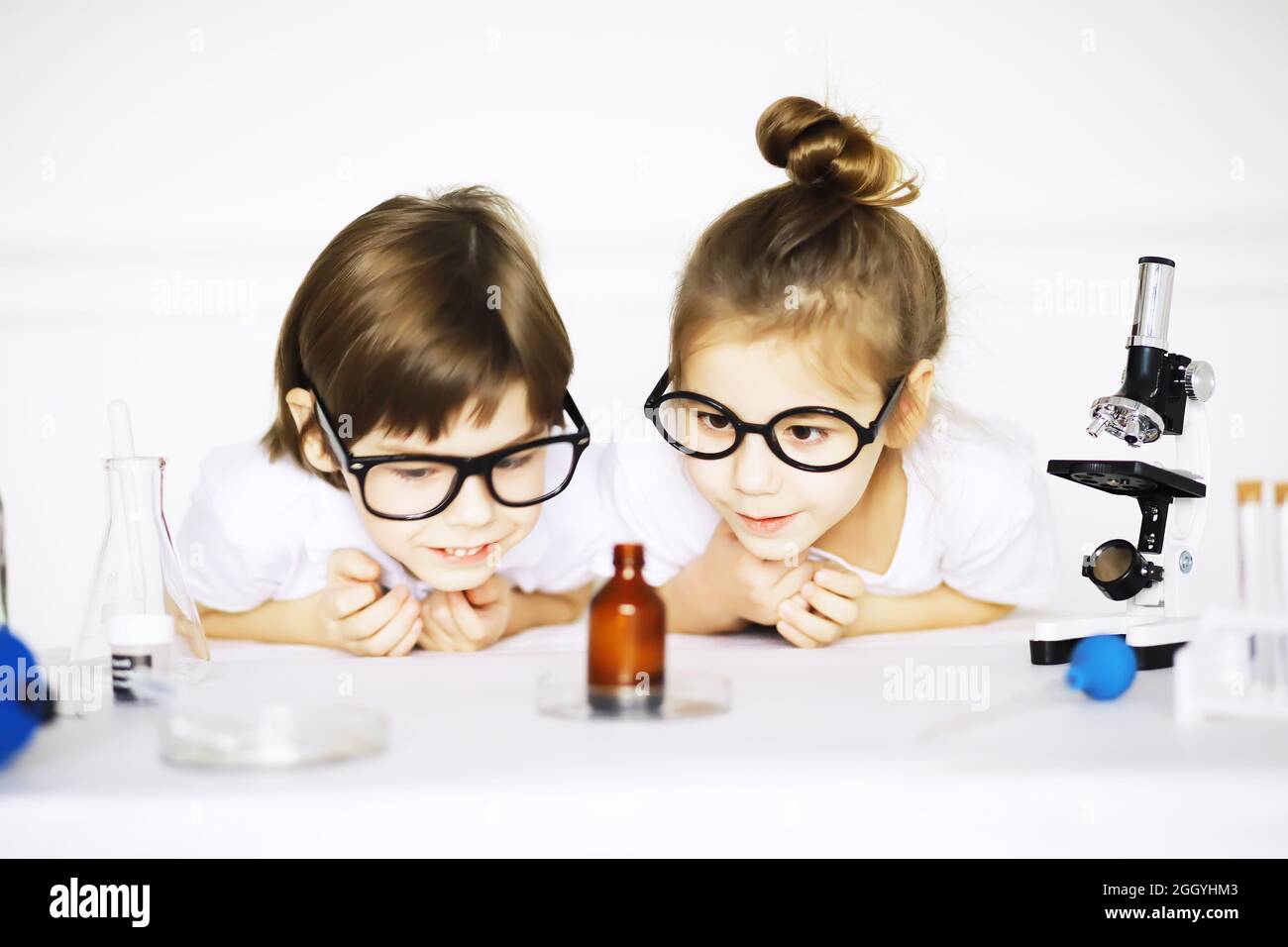 Two cute children at chemistry lesson making experiments isolated on ...