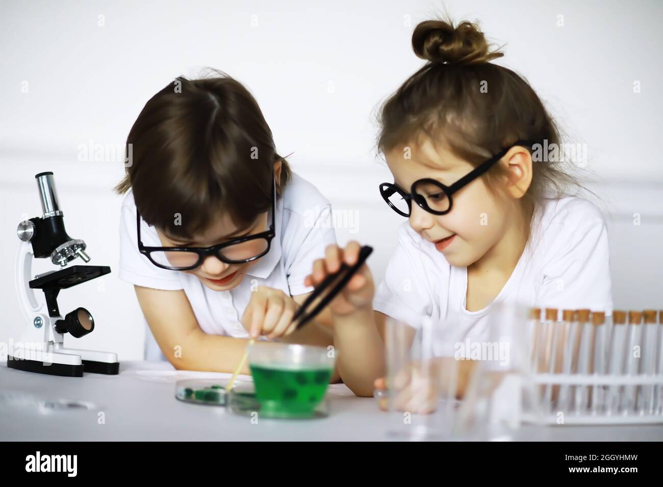 Two cute children at chemistry lesson making experiments isolated on ...