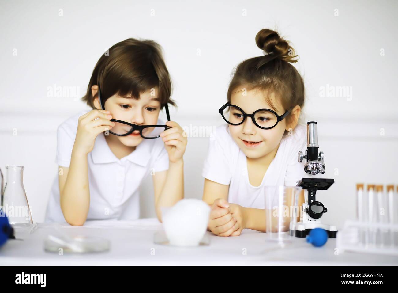 Two cute children at chemistry lesson making experiments isolated on ...