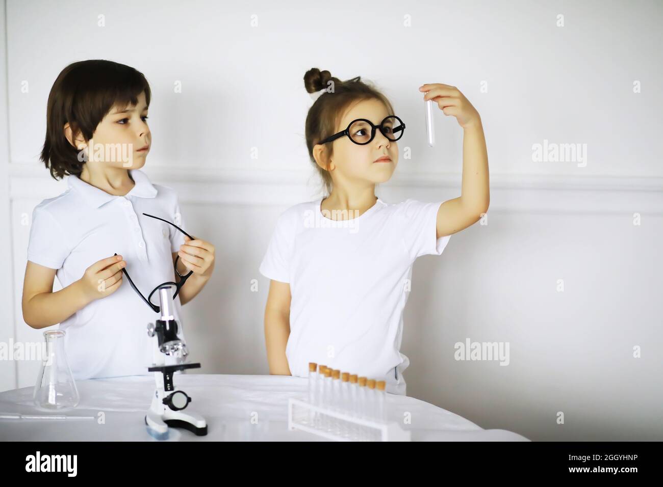 Two cute children at chemistry lesson making experiments isolated on ...