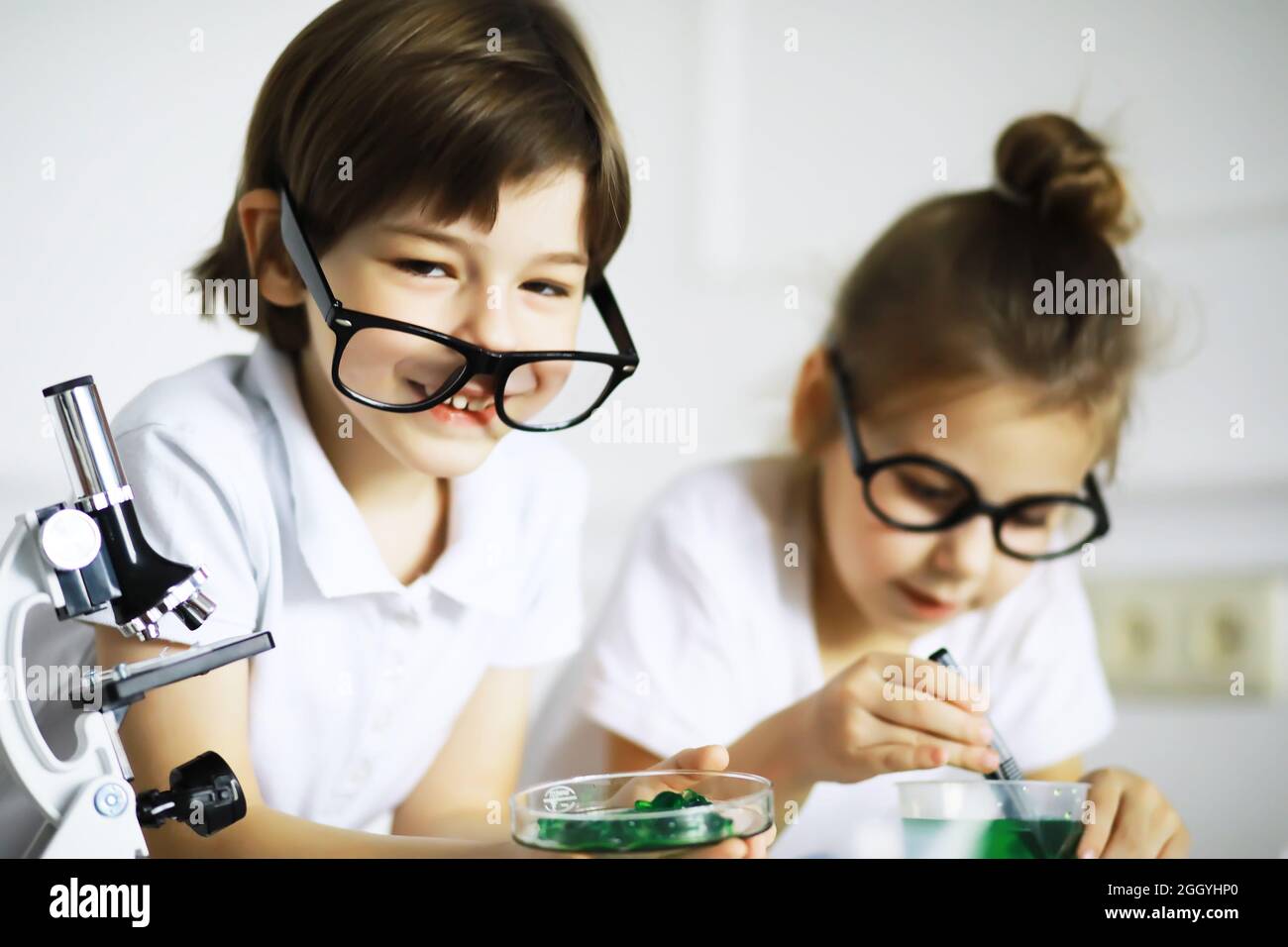 Two cute children at chemistry lesson making experiments isolated on ...
