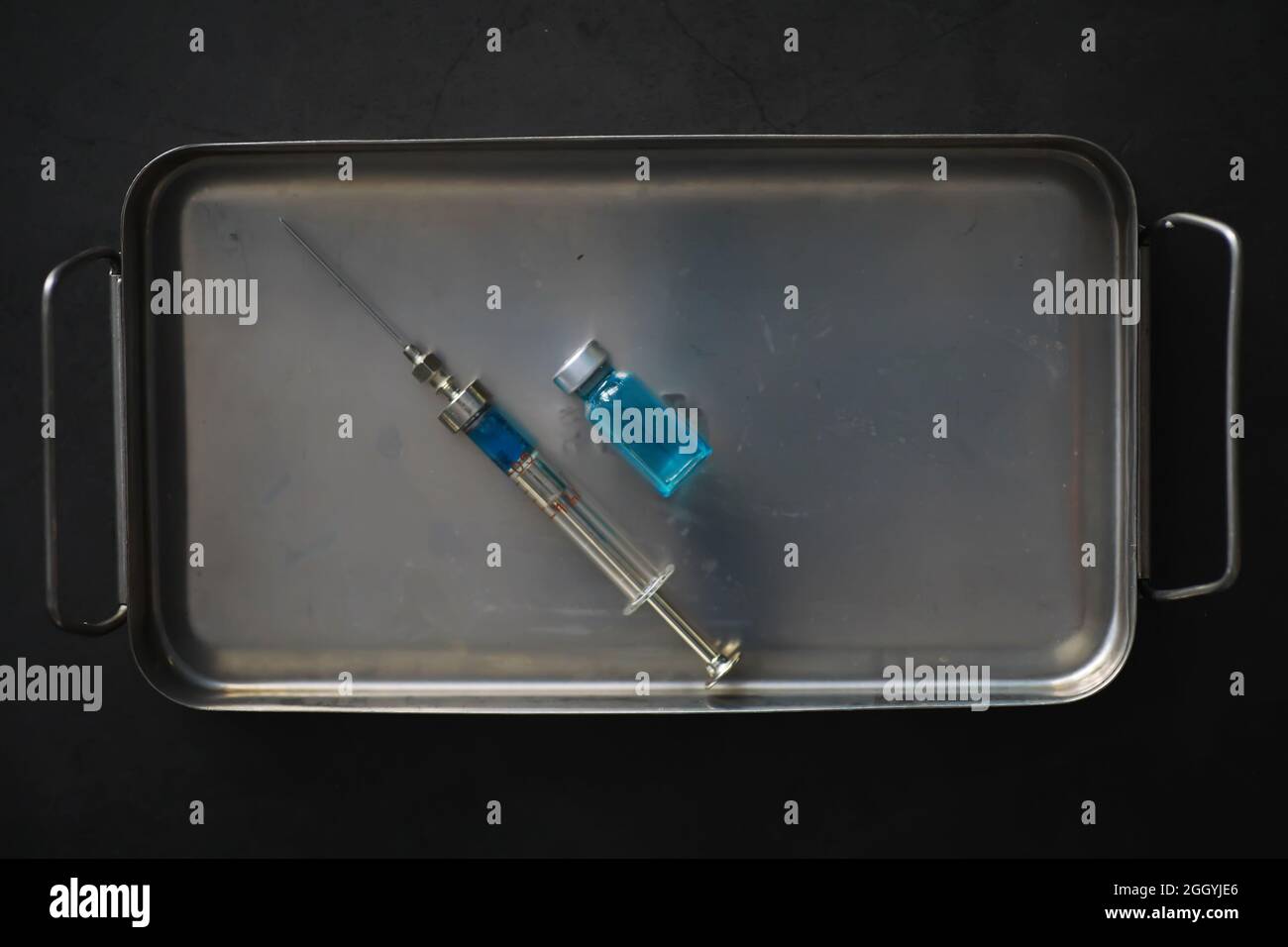 small jars with injection and syringe for injection on blue background ...