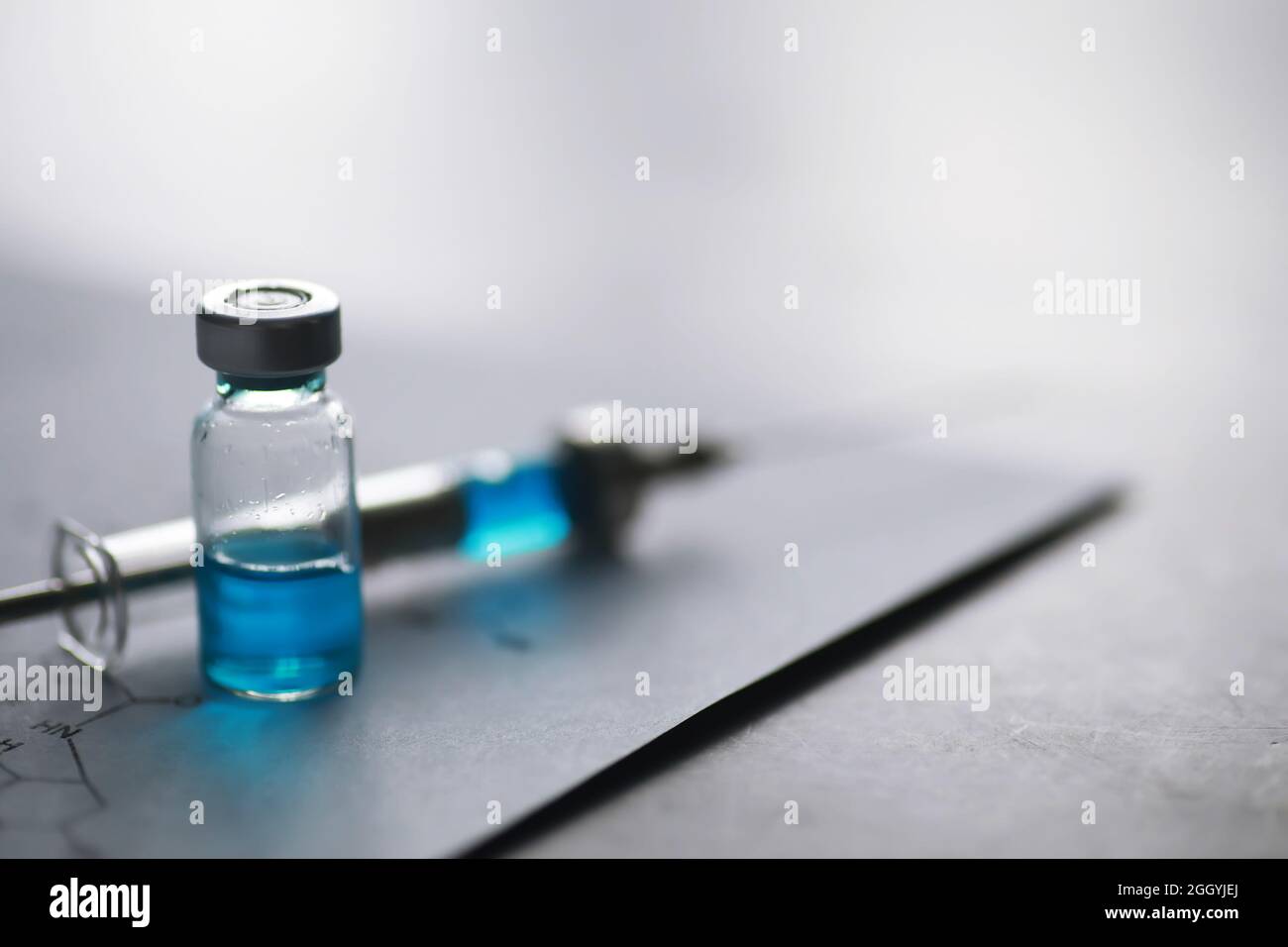 small jars with injection and syringe for injection on blue background ...
