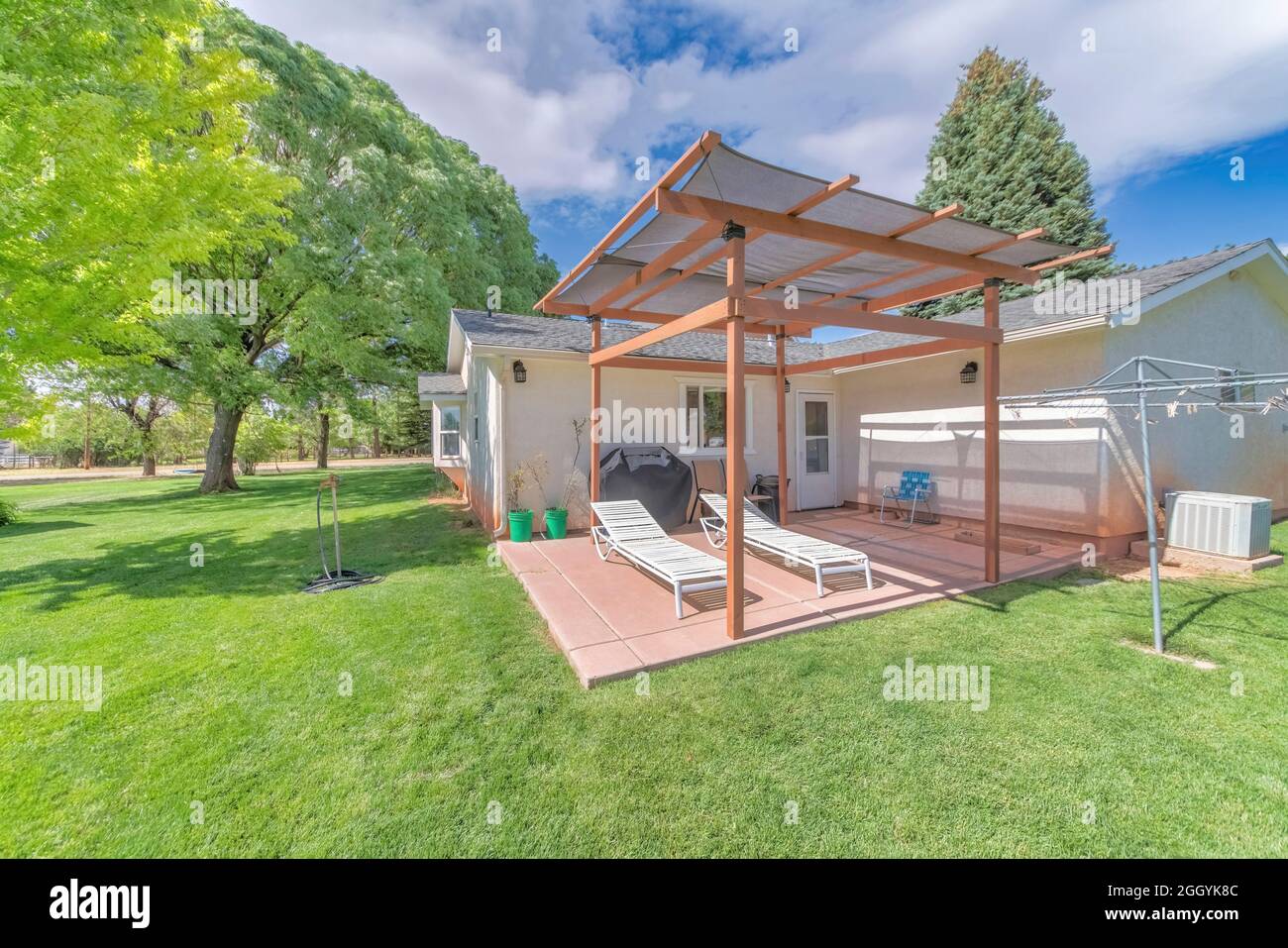 Outdoor patio of a house with two lounge chairs under the shade Stock ...