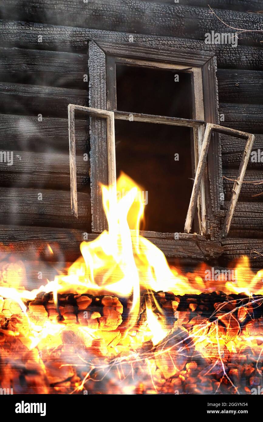 Wooden house after the fire. Coals on the logs. The ashes of the house ...