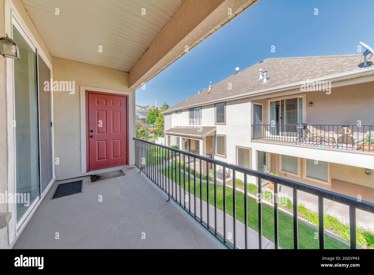 Veranda of a house with red wooden door and sliding glass door Stock ...