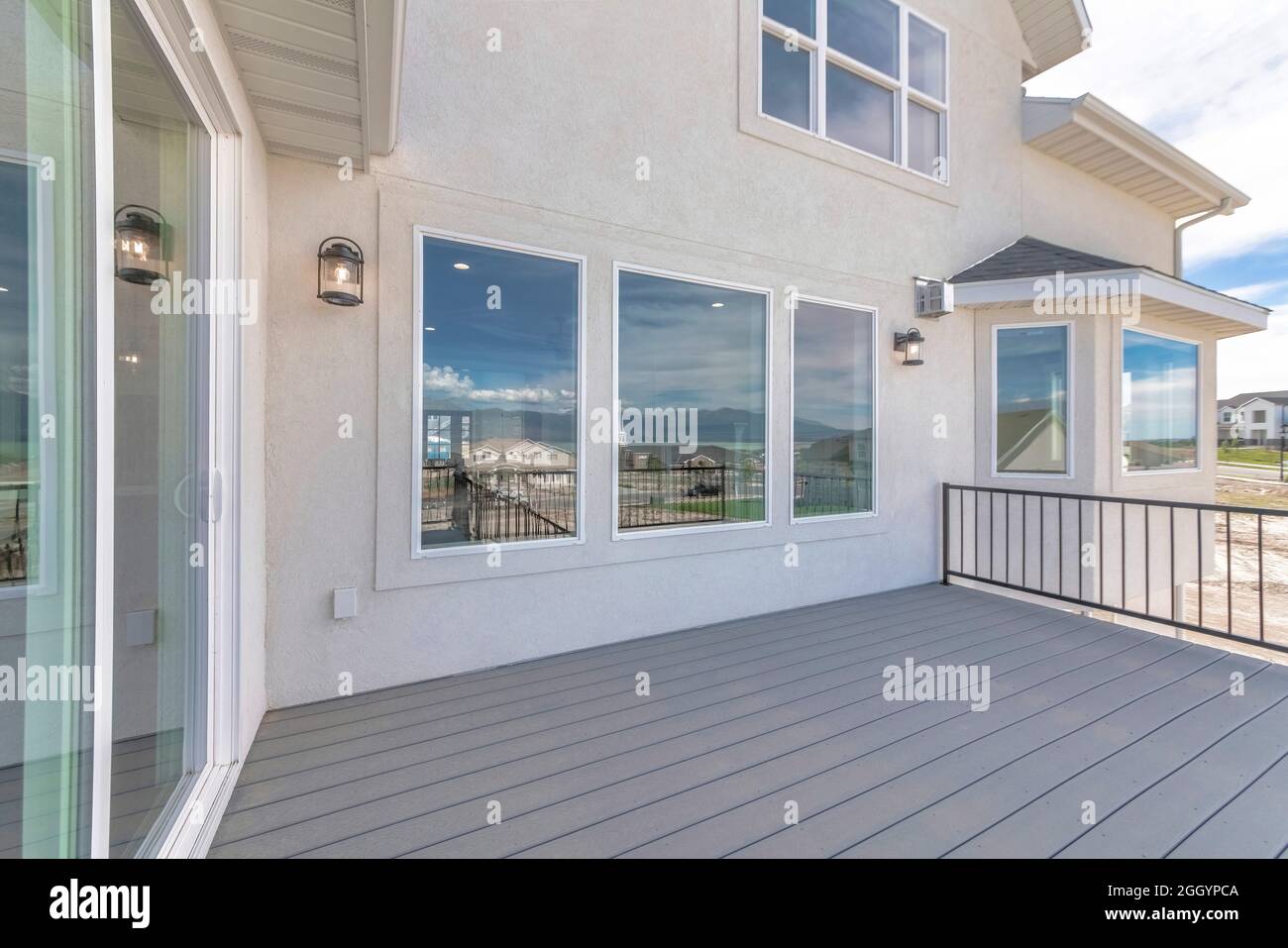 Deck of a house with sliding glass windows and open wall lamps Stock ...