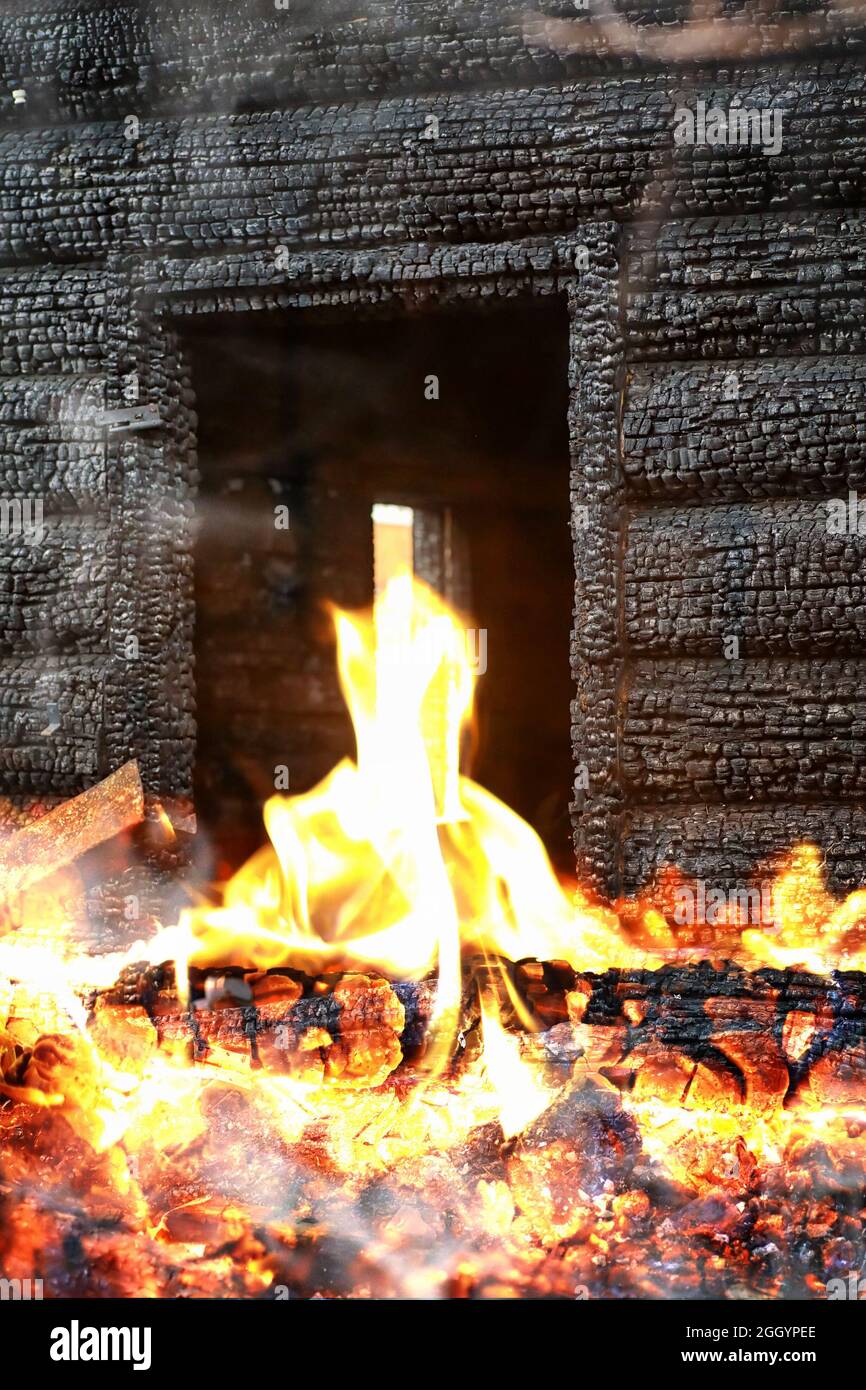 Wooden house after the fire. Coals on the logs. The ashes of the house ...