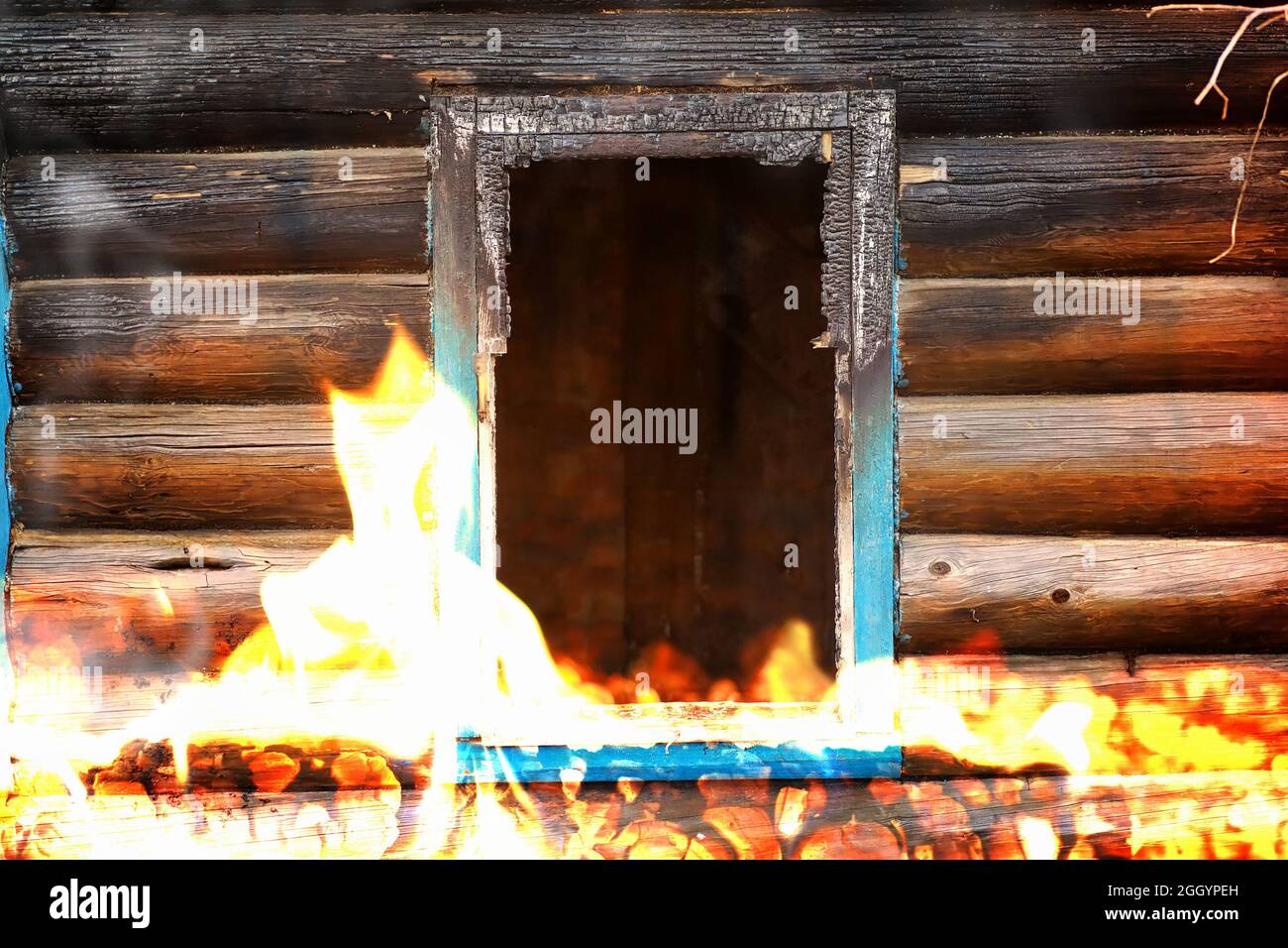 Wooden house after the fire. Coals on the logs. The ashes of the house ...