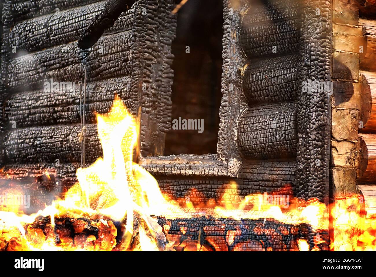Wooden house after the fire. Coals on the logs. The ashes of the house ...