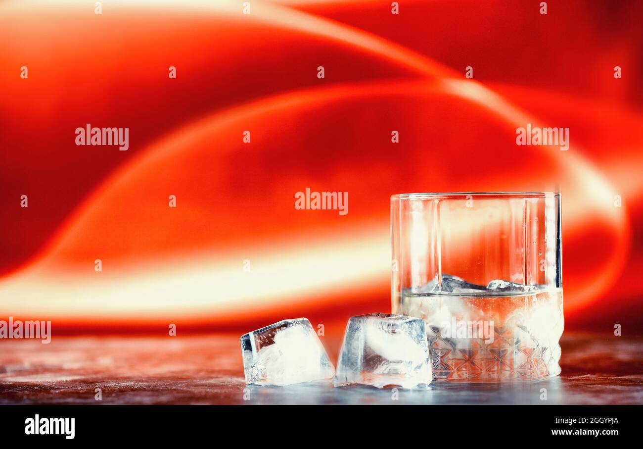A glass of hard alcohol with ice on a bar counter. Whiskey with soda in ...