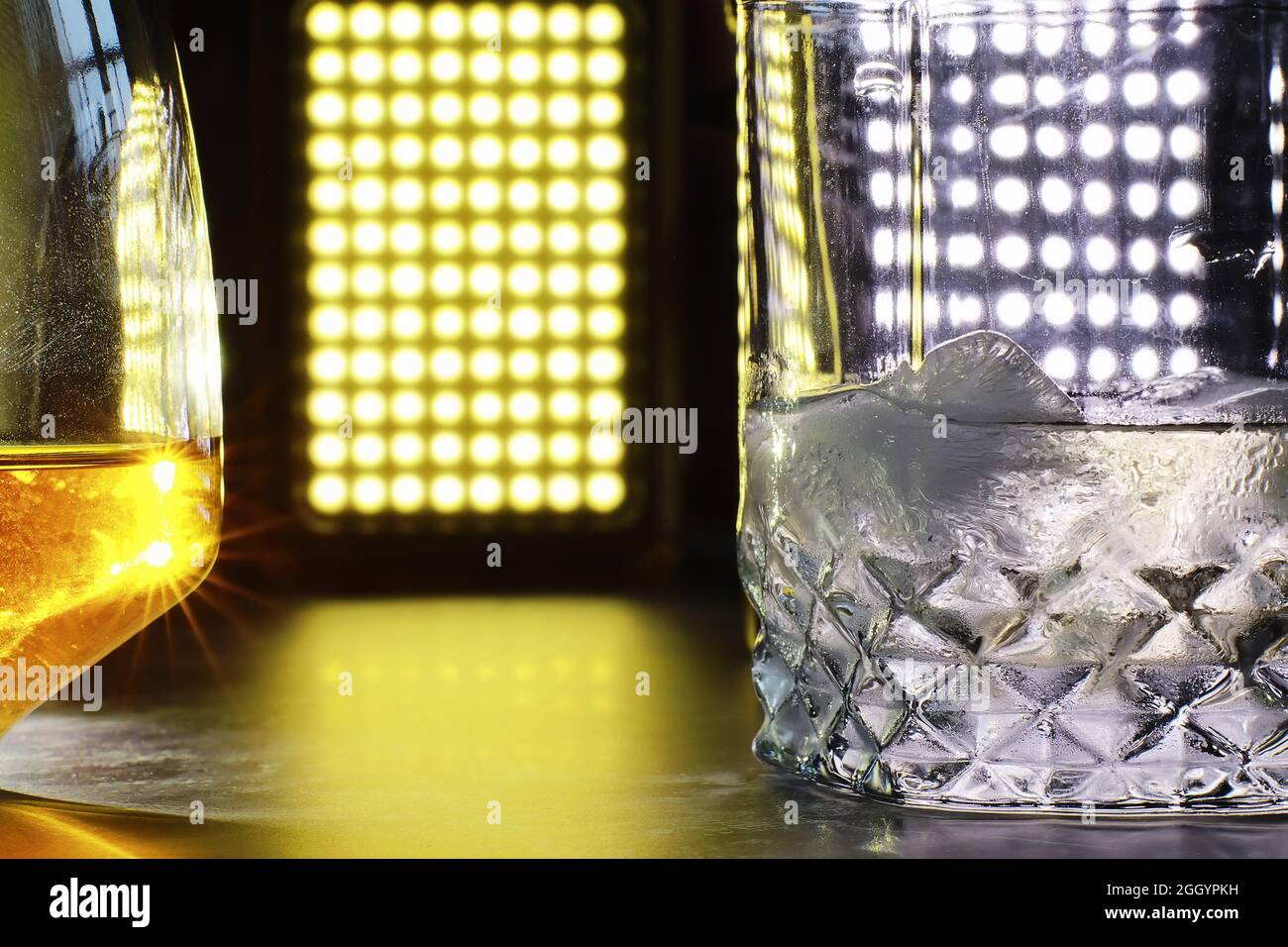 A glass of hard alcohol with ice on a bar counter. Whiskey with soda in ...