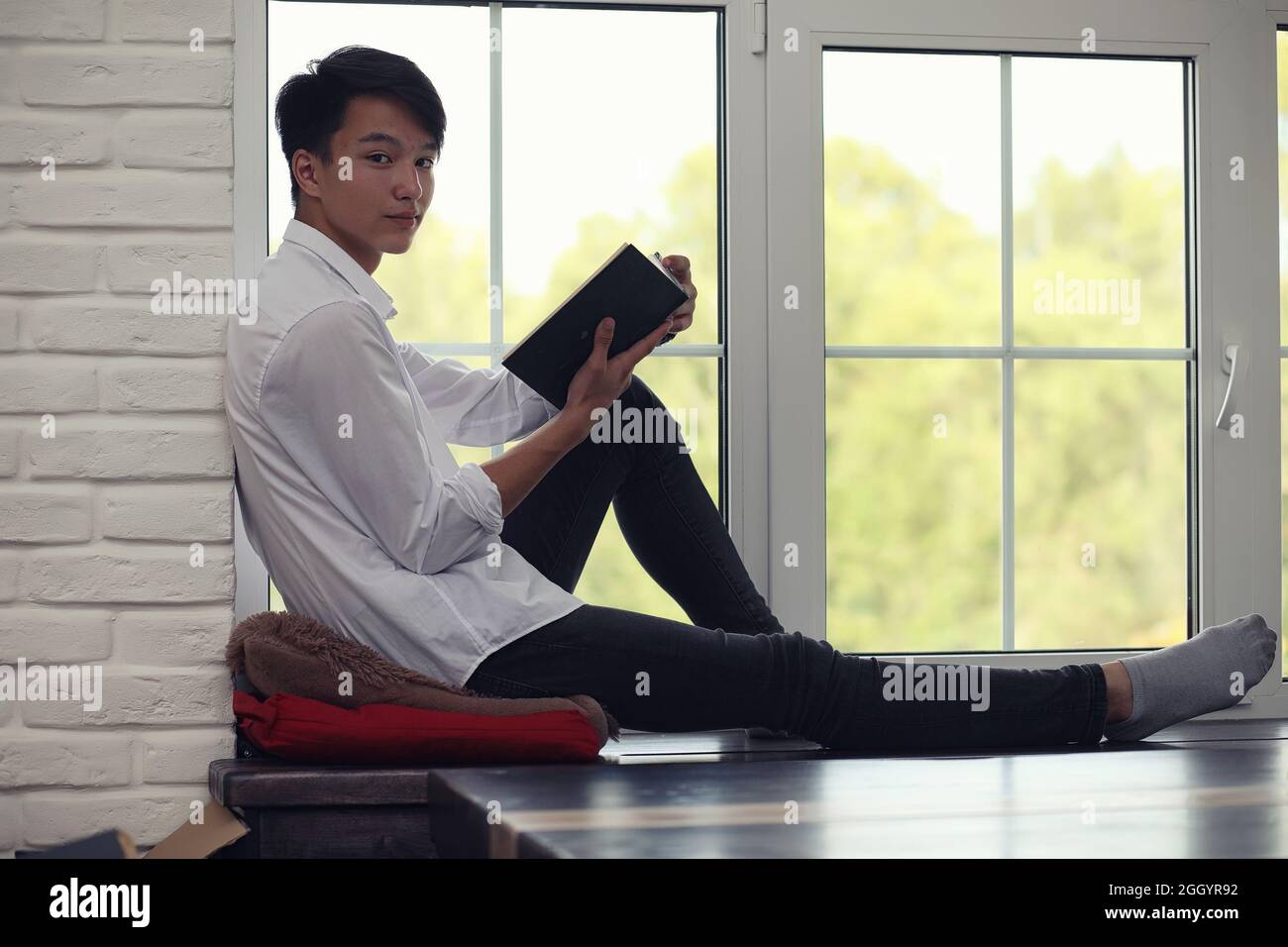 Asian young man student with books in hands Stock Photo - Alamy