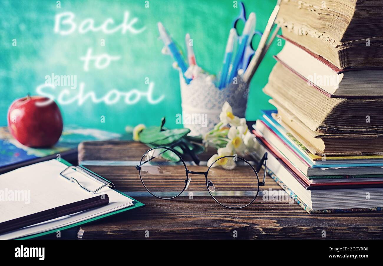 Education concept. A stack of textbooks and a book on the desk with ...