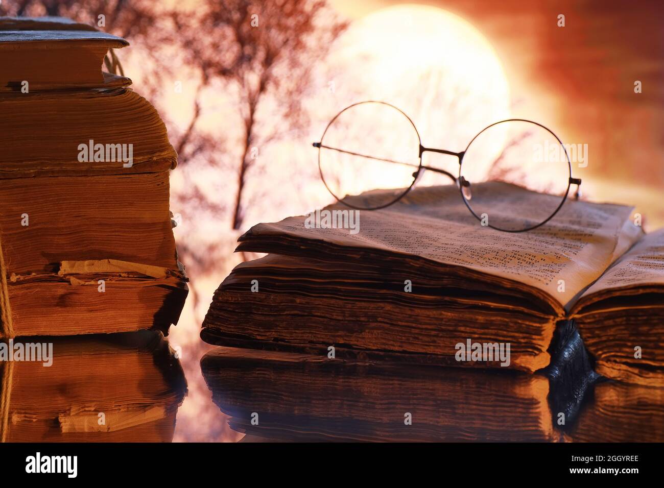 Vintage glasses on an old retro book on a background of the moon ...