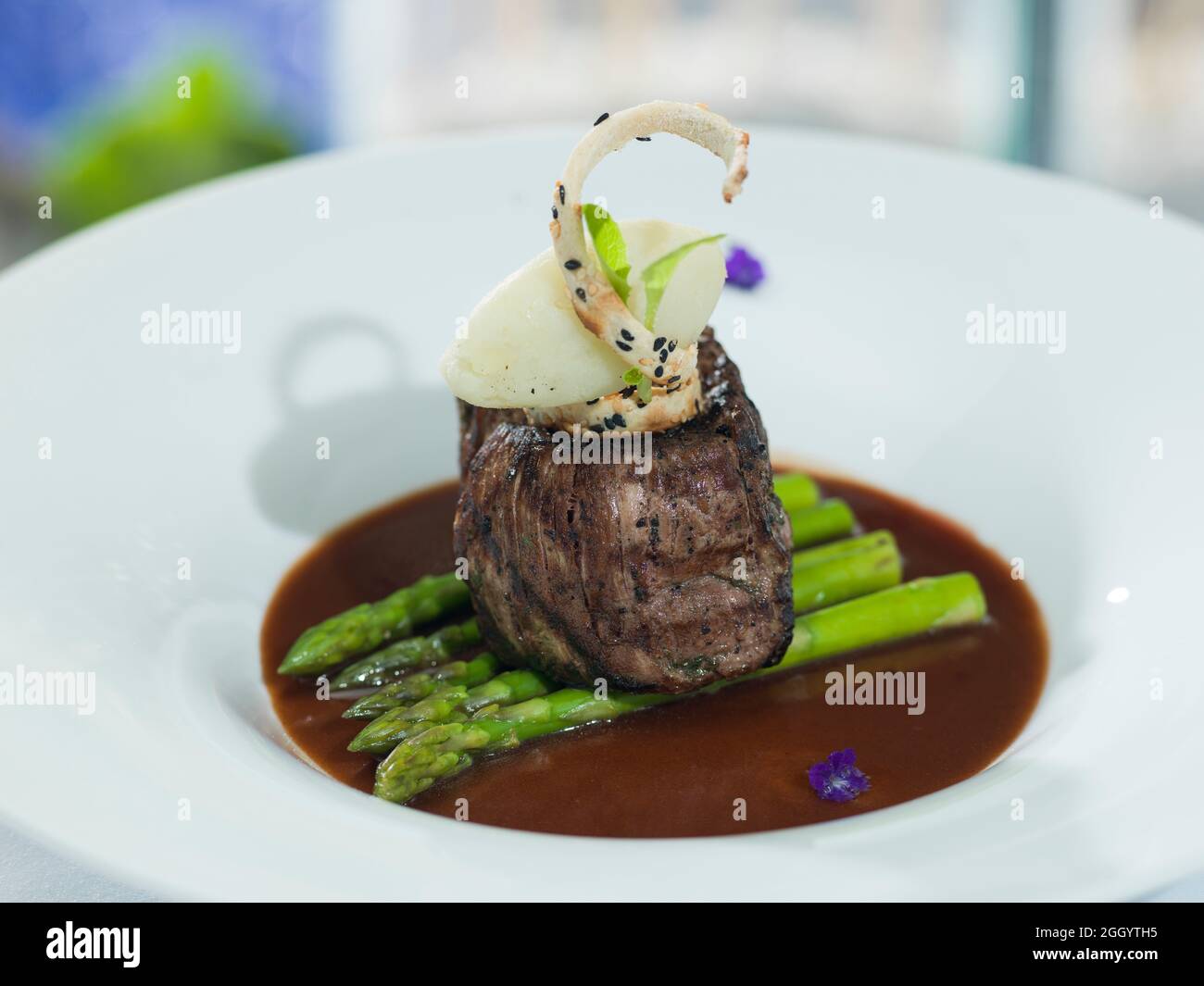 Tasty filet mignon on a bed of asparagus in black pepper sauce Stock ...