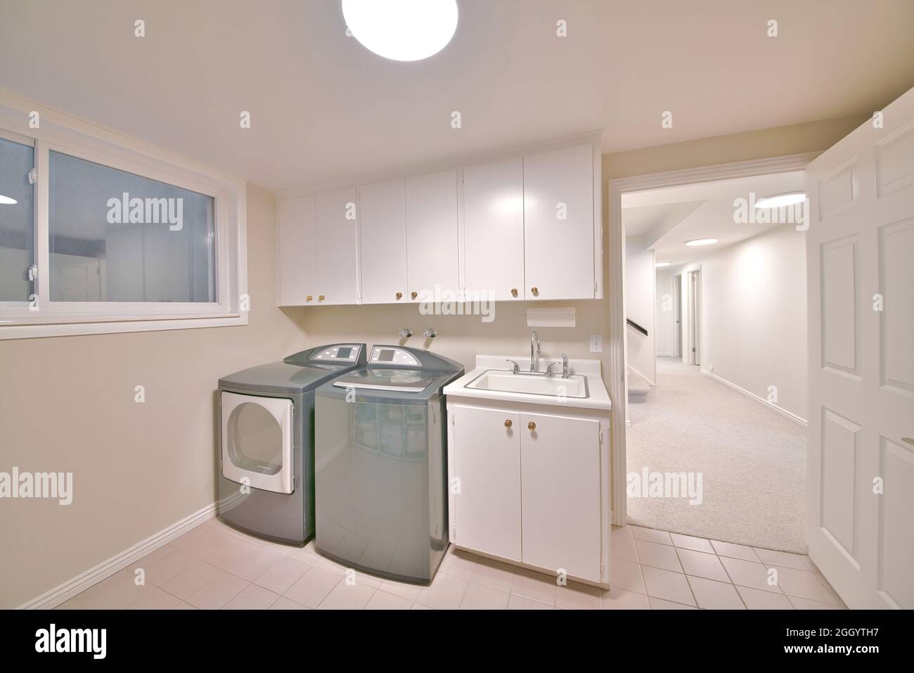 Interior of a laundry room with an open white door and a view of the ...