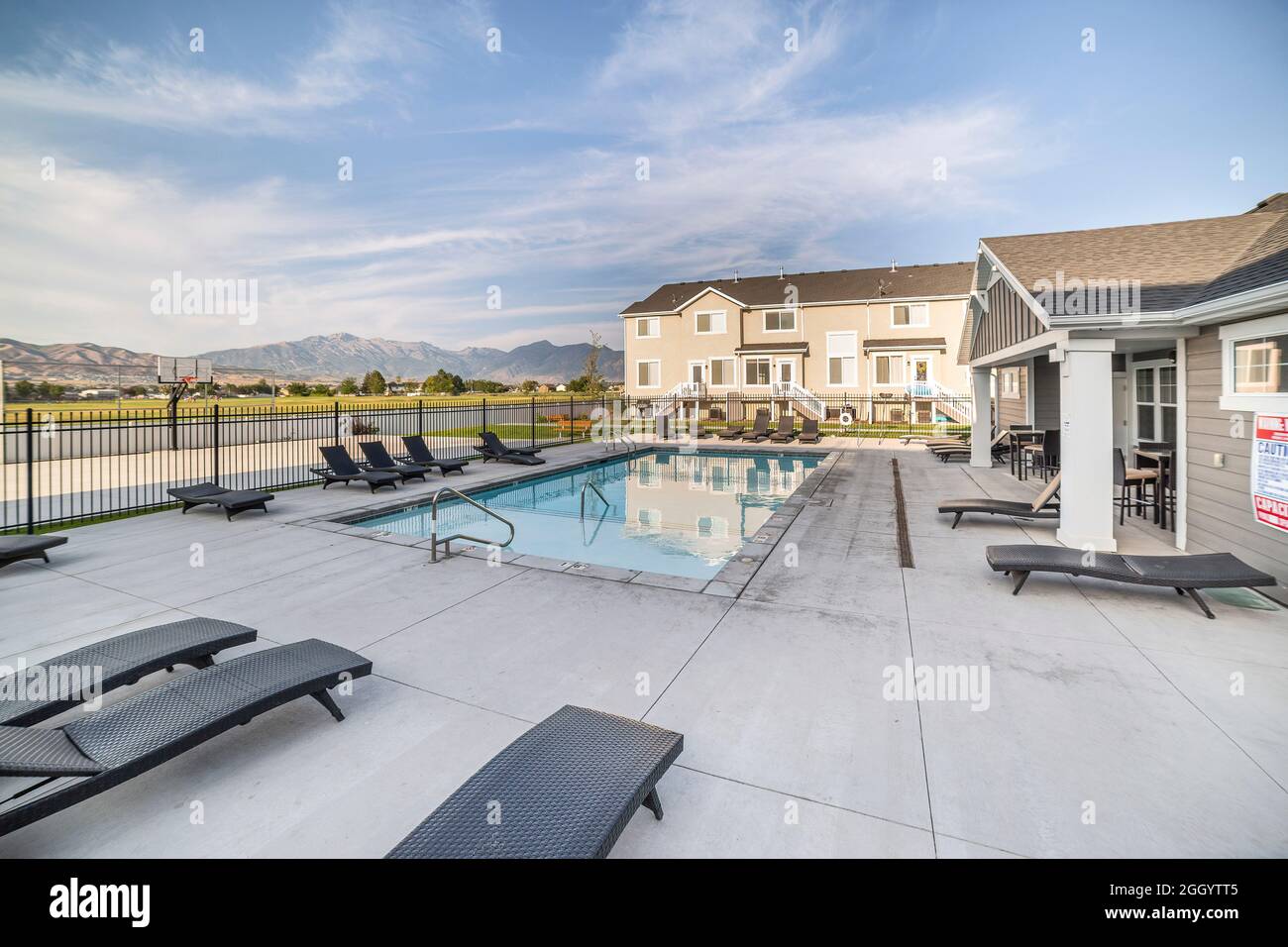 Community pool of a residential area with black lounge chairs and ...