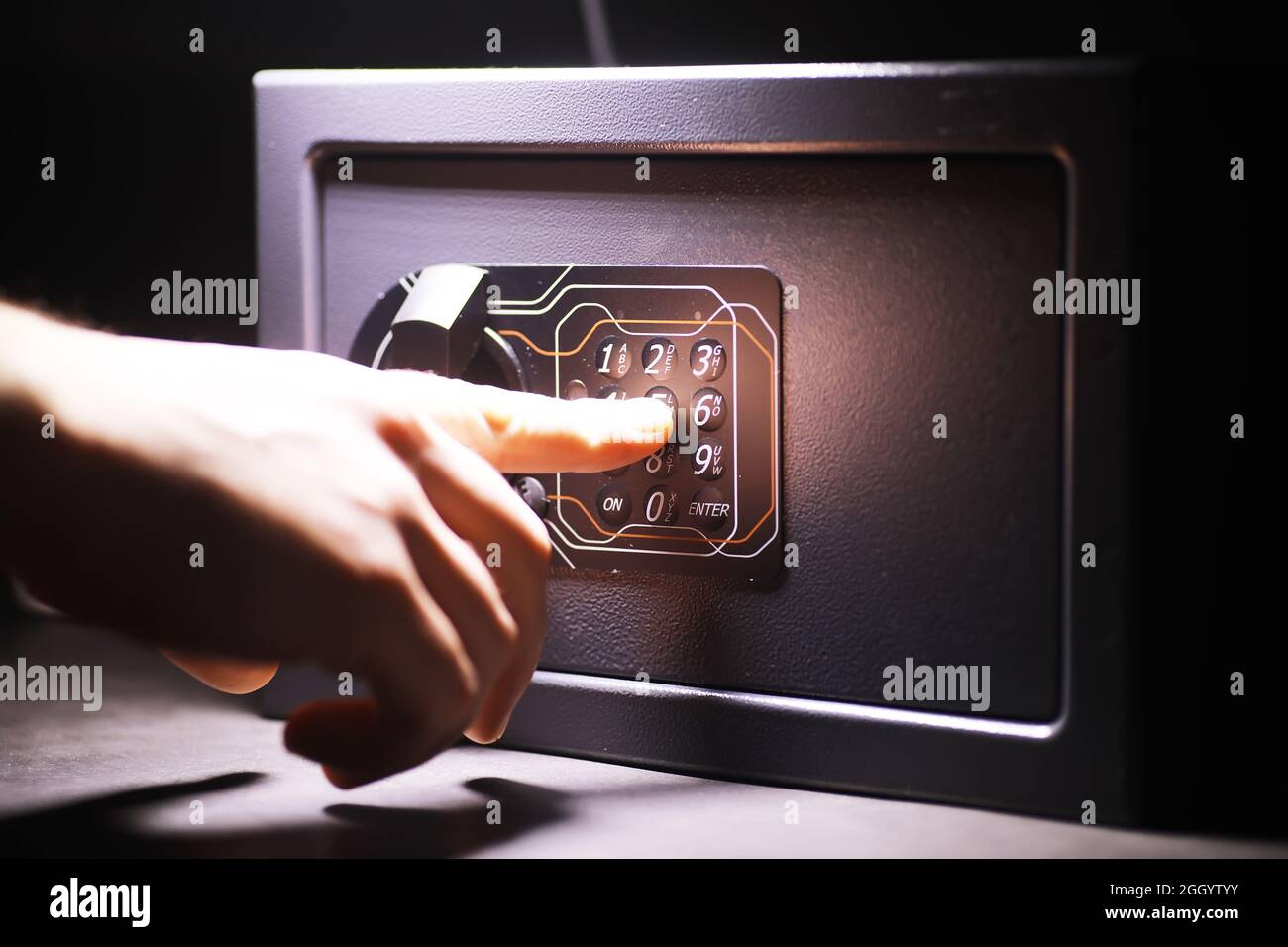 Steel safe with money. Hand putting password in the safety money box in ...