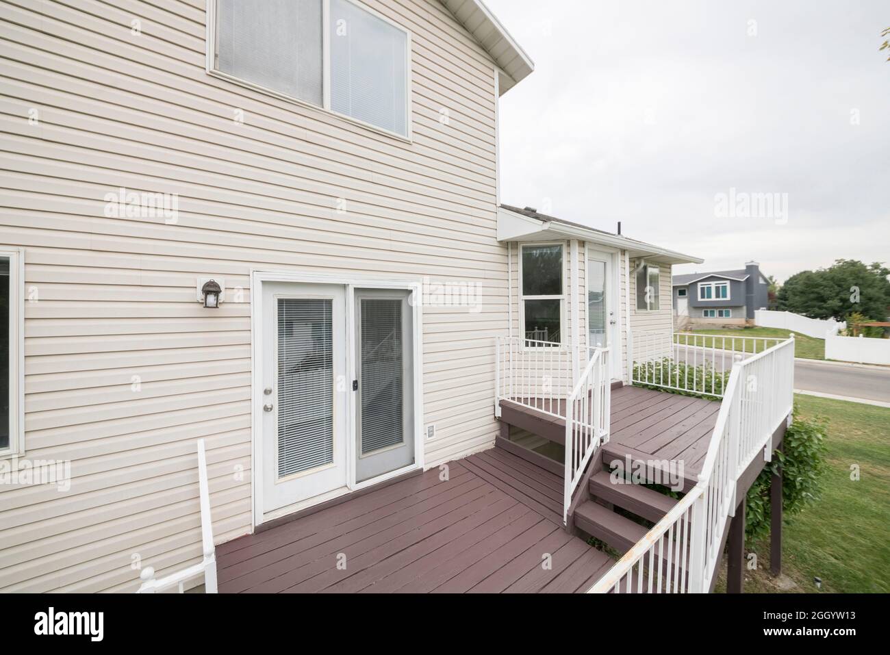 Outdoor veranda with wooden flooring and white railings Stock Photo - Alamy