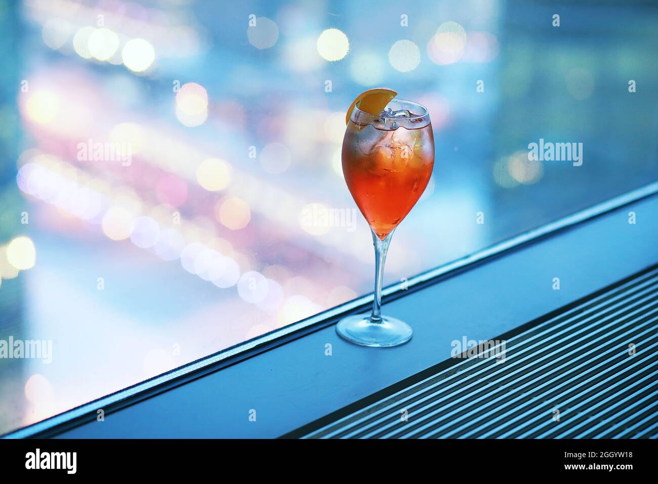 Cocktail glasses on the windowsill by the glass of a tall building ...