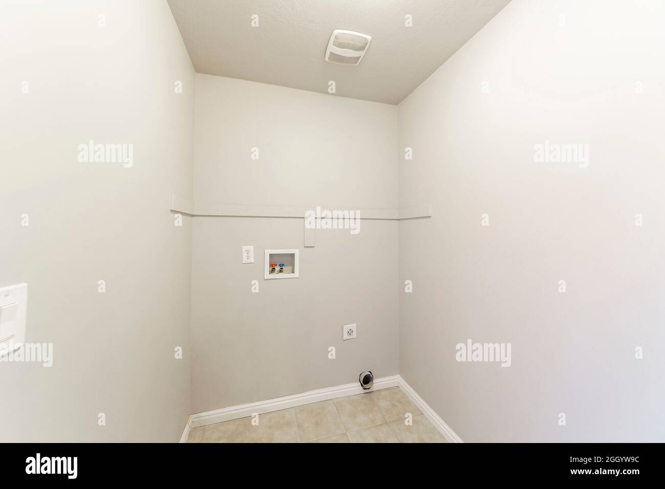 Tiled empty laundry room with hot and cold laundry connections Stock ...